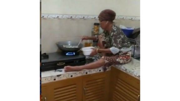 Viral! Begini Gaya Seorang Nenek yang Masak sambil Duduk di Atas Meja, Santuy Banget Euy!